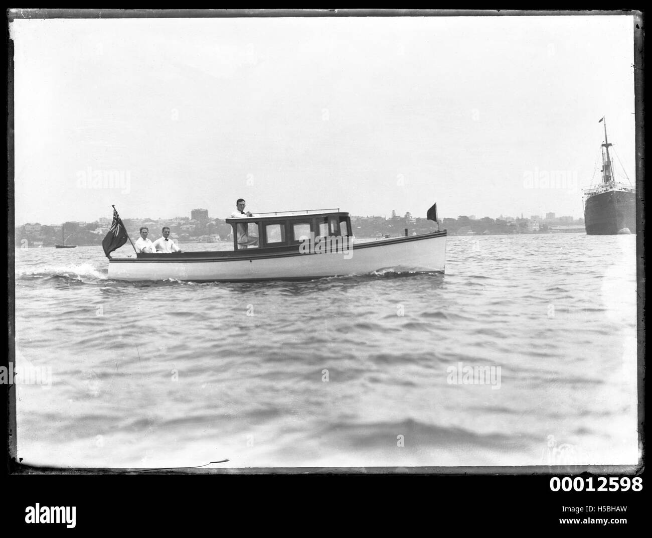 A motor launch on a harbor, captured in this photograph, depicting a ...