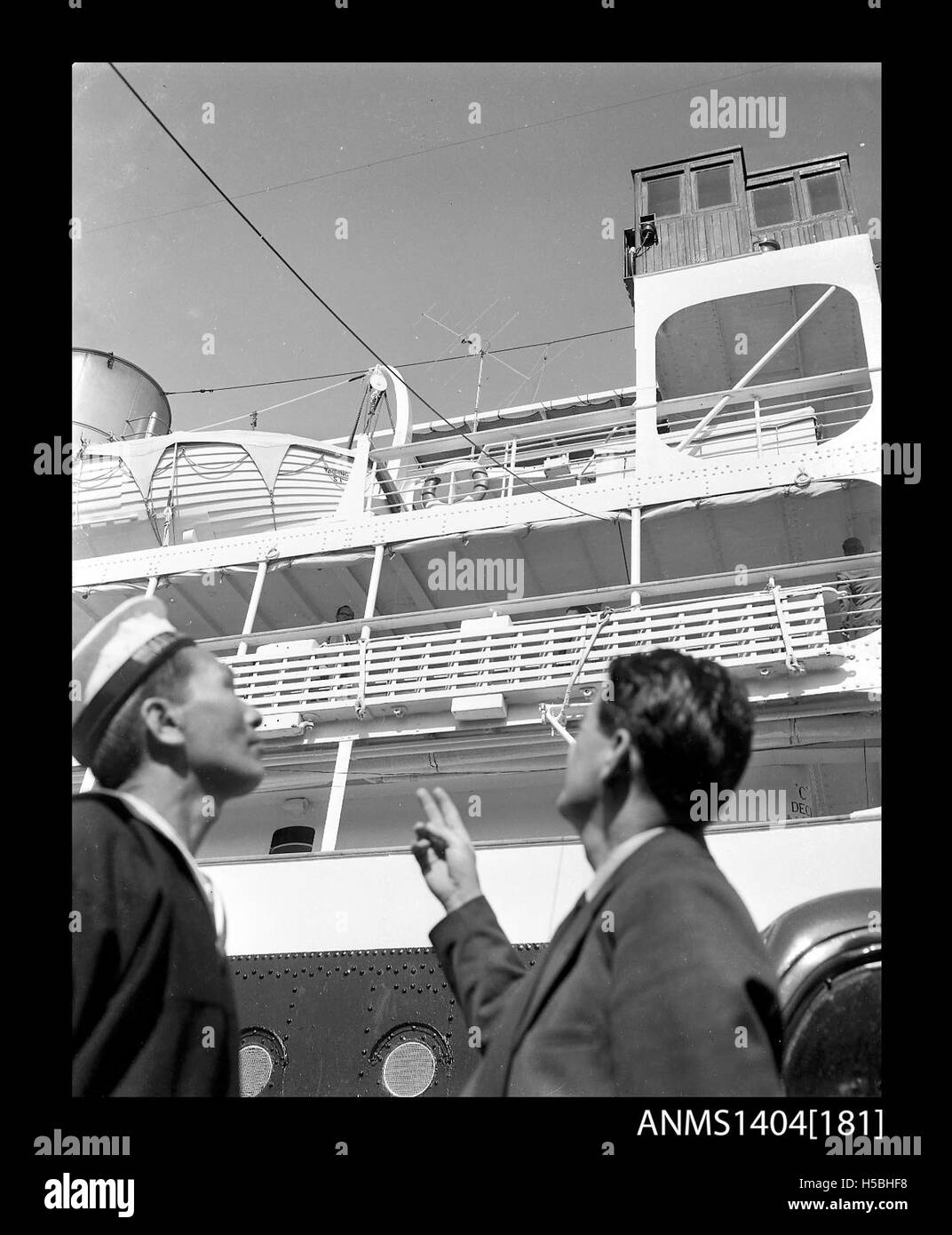A sailor and a man are shown observing a television aerial on board the ...
