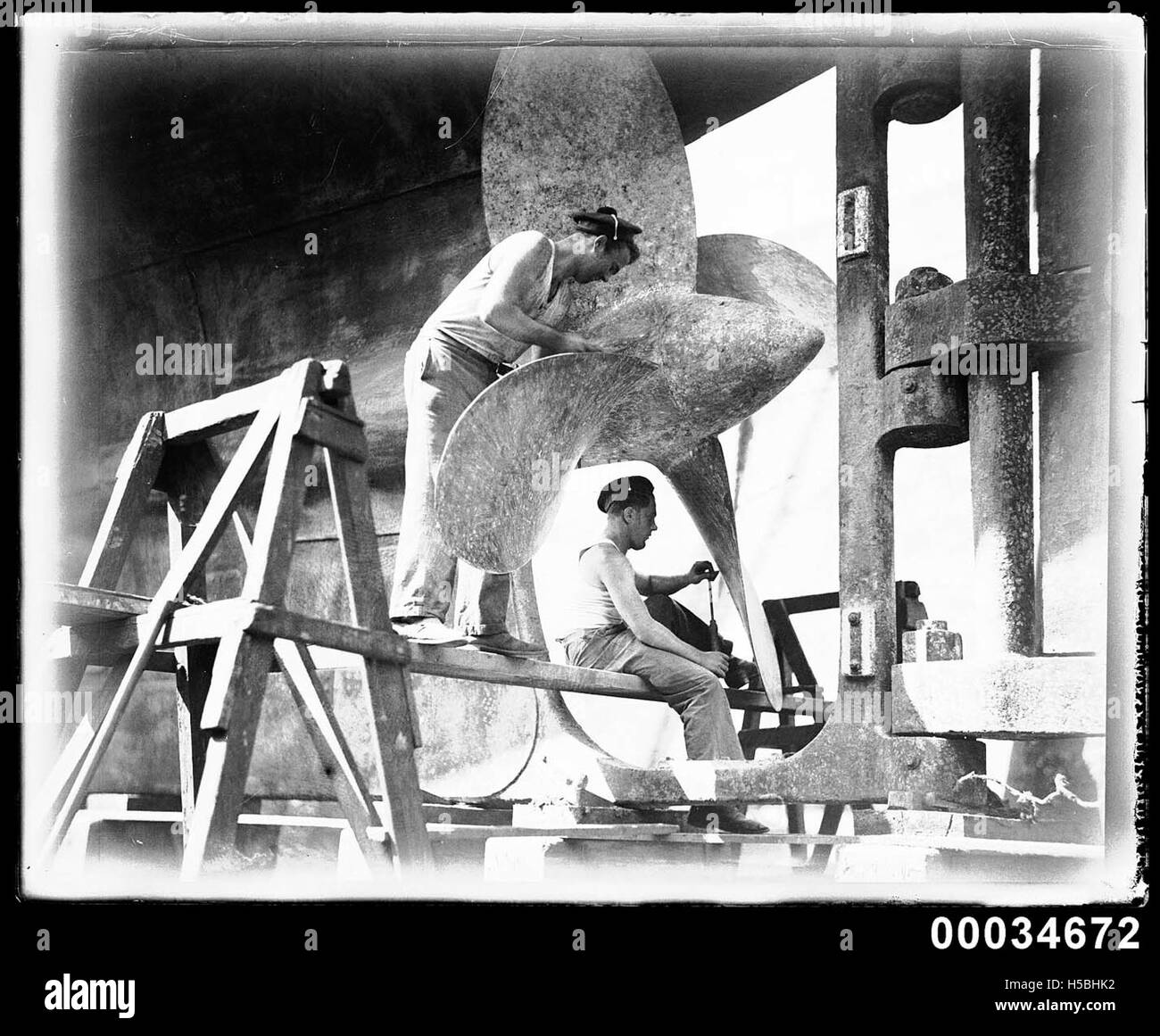Photograph showing two sailors cleaning the propeller of the French ...