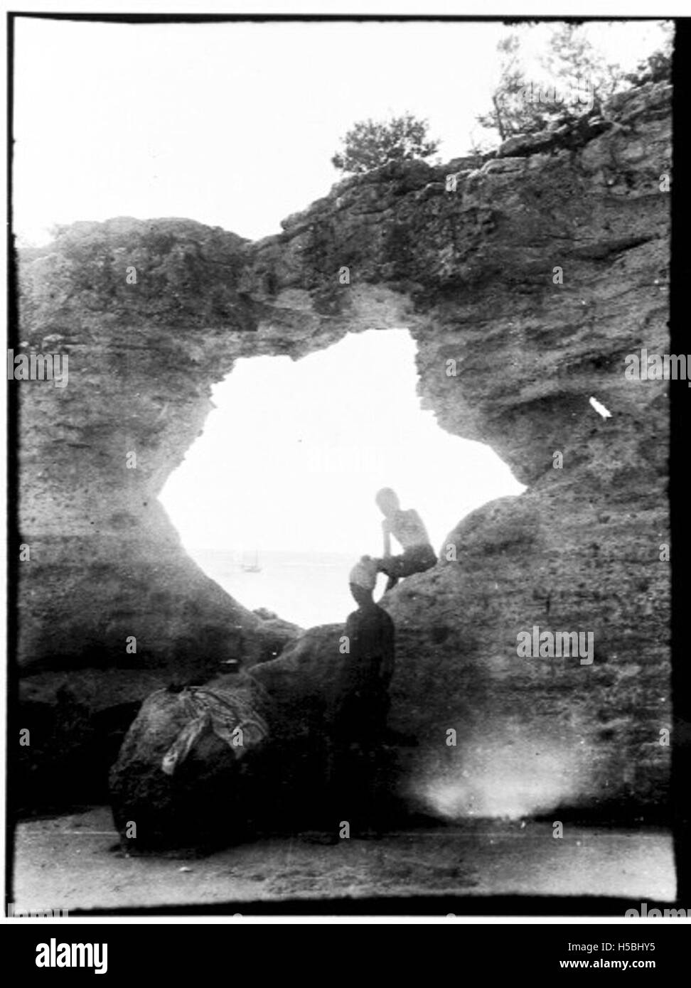 This photograph depicts a hole in a rocky cliff wall, likely formed by ...