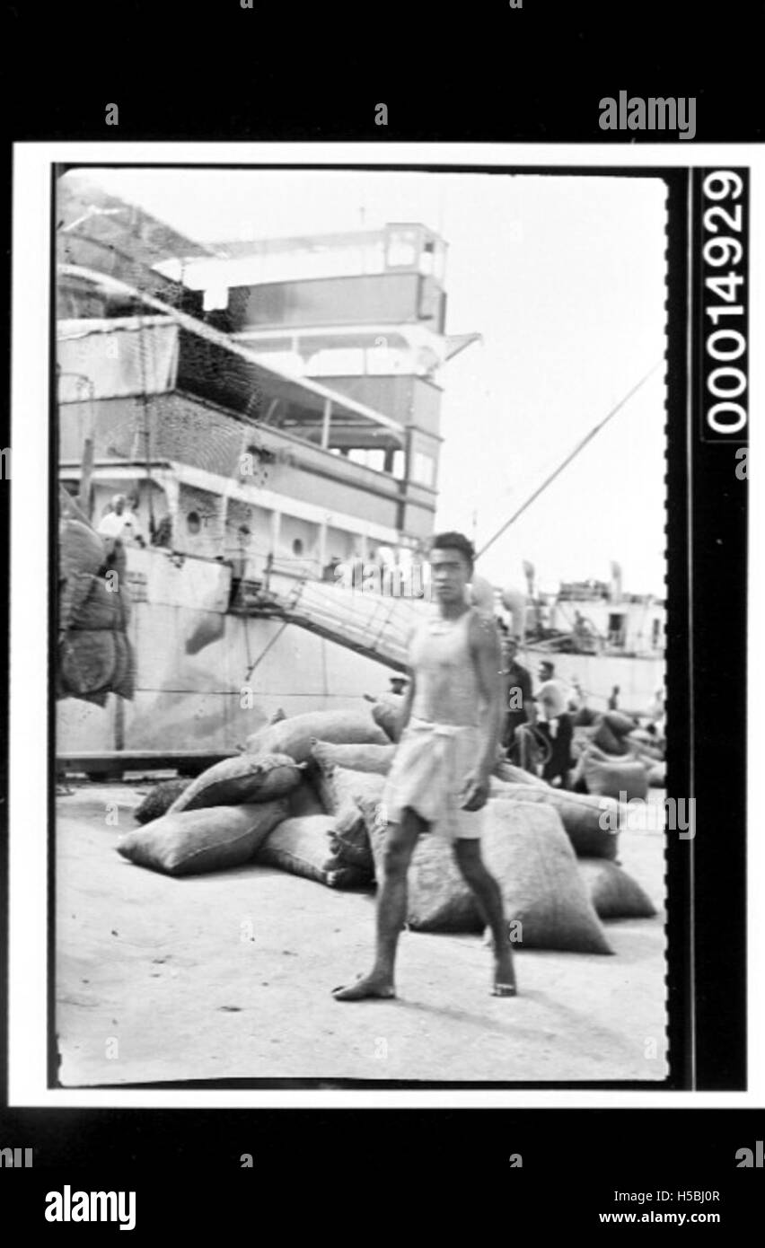 This photograph shows wharf laborers working at the Nuku'alofa port in ...