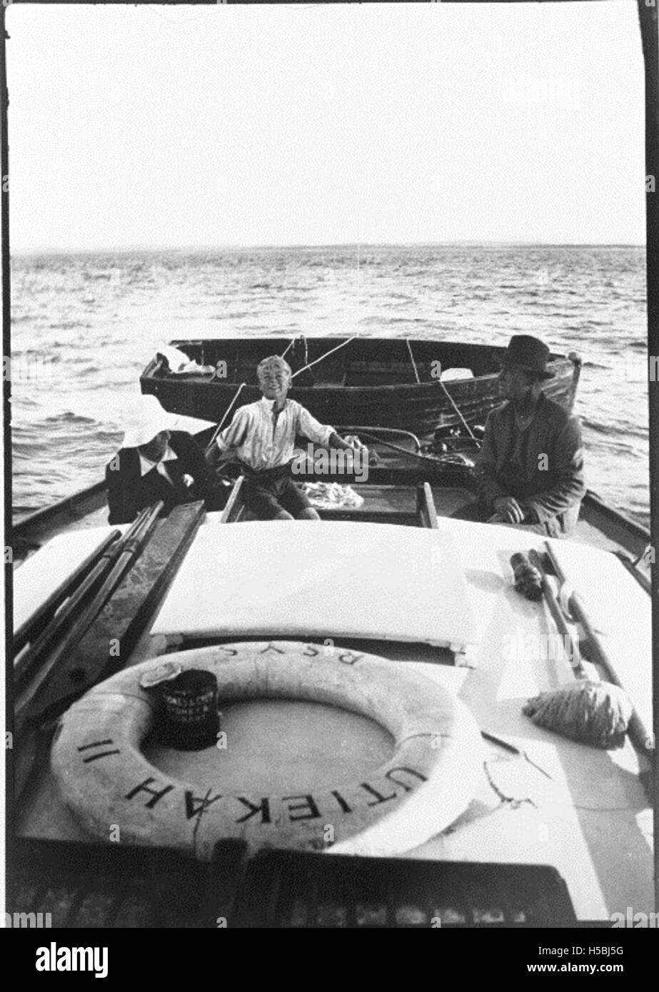 A crew member is seen holding the tiller aboard the ship UTIEKAH II, an ...