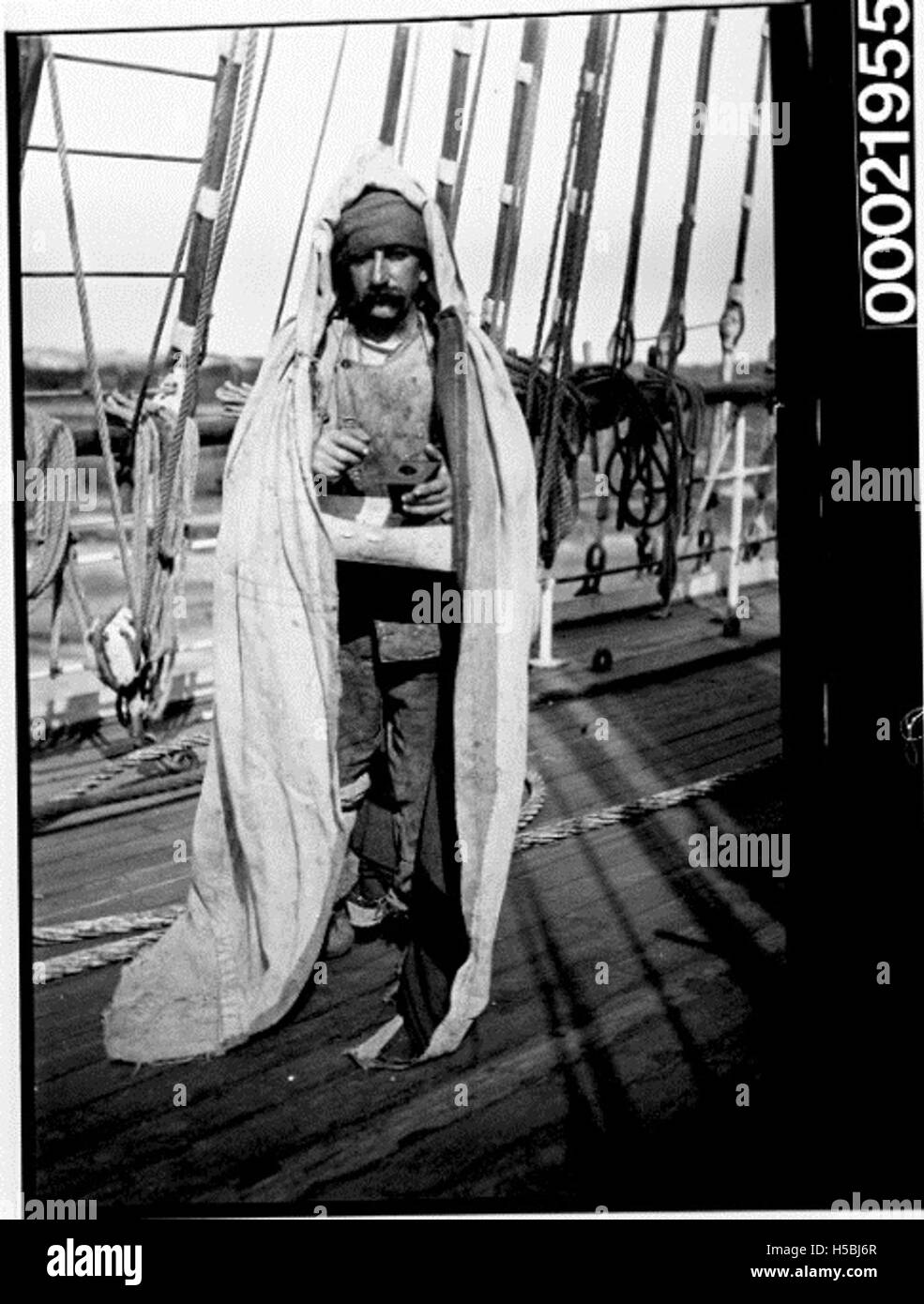 An unidentified mariner stands on the deck of a vessel between 1890 and ...