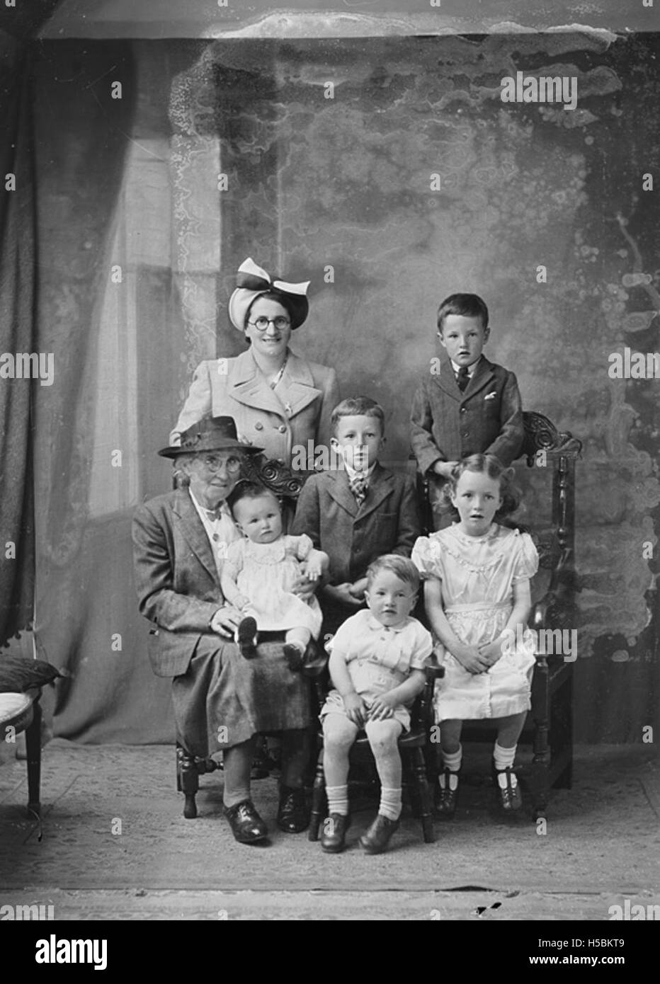 A formal photograph depicting family members posed together, capturing ...