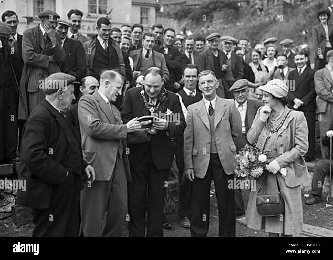 A historical photograph capturing people playing quoits, a traditional ...