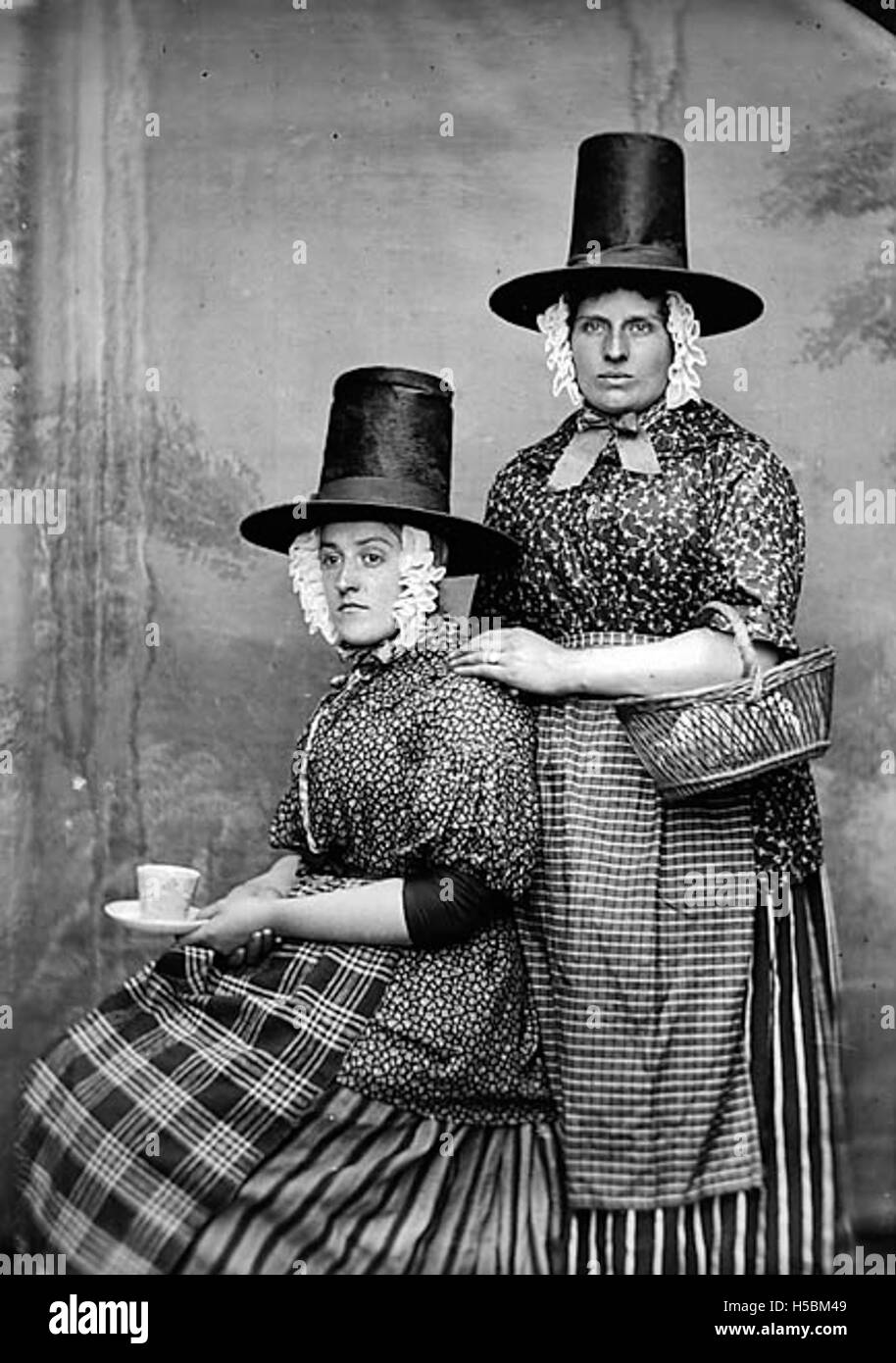 The photograph features two women dressed in traditional national ...