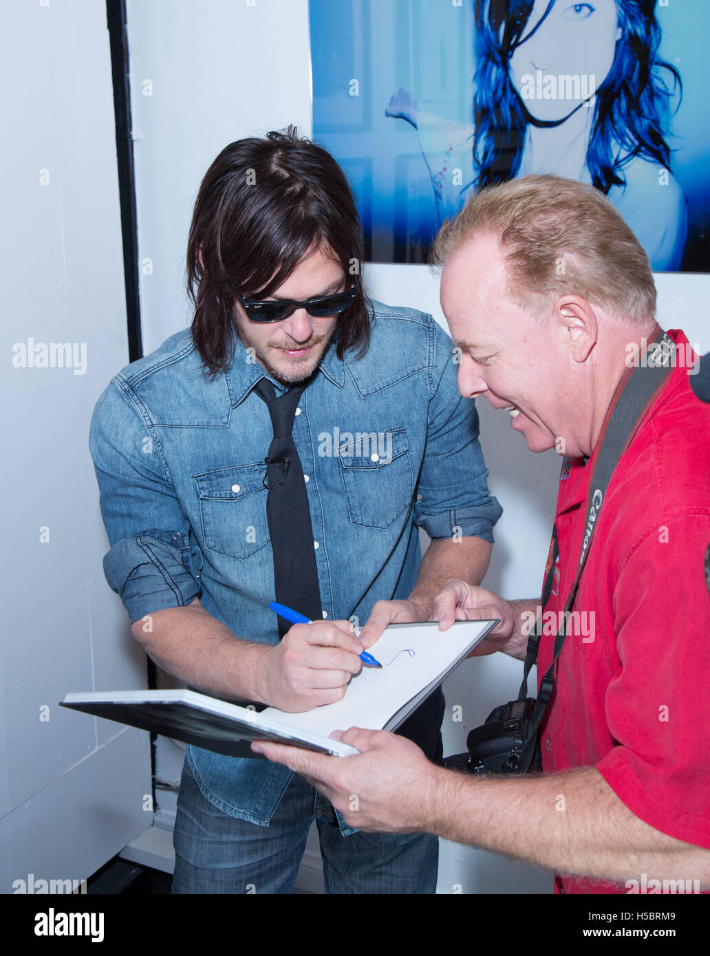 Actor Norman Reedus signs his book to the guest at Norman Reedus: A ...
