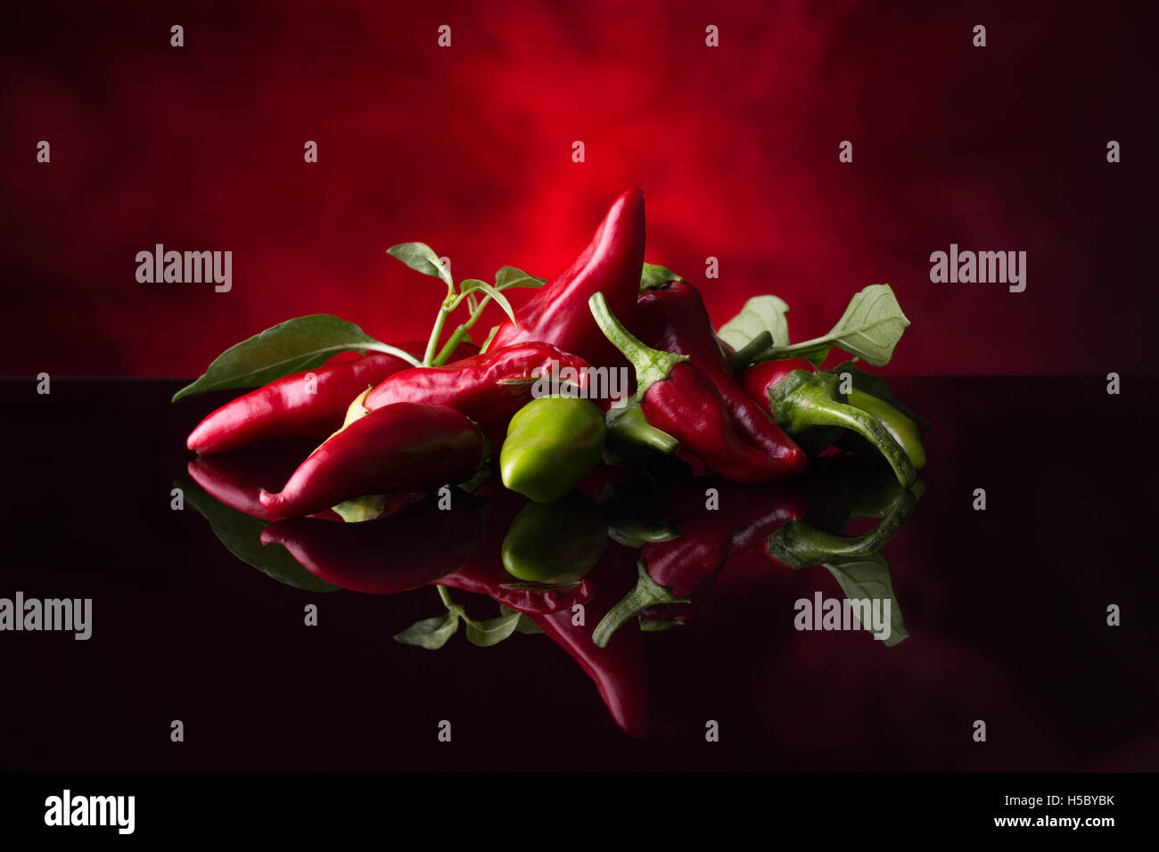 red chili peppers on black and red background Stock Photo - Alamy