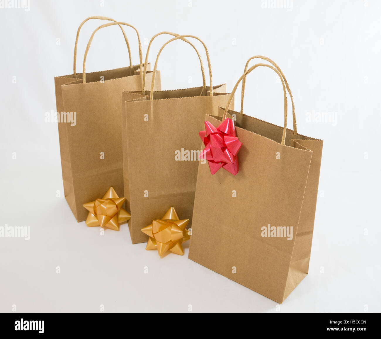 Three paper bag parcels and bows on white background Stock Photo - Alamy