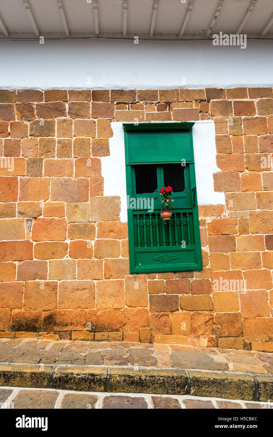Green window with red flowers in a beautiful colonial building in ...