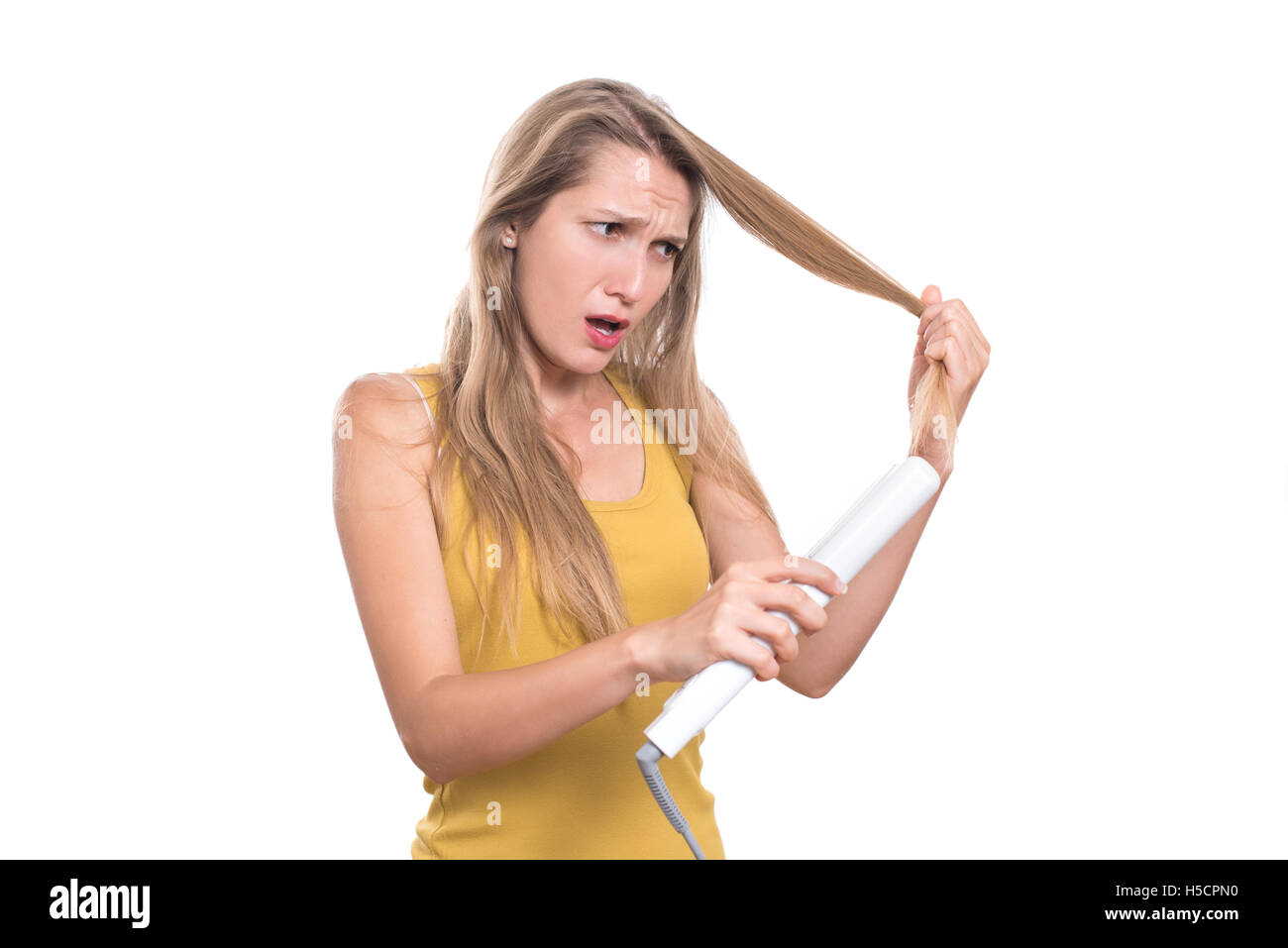 Young woman damage her hair with straightening iron Stock Photo - Alamy