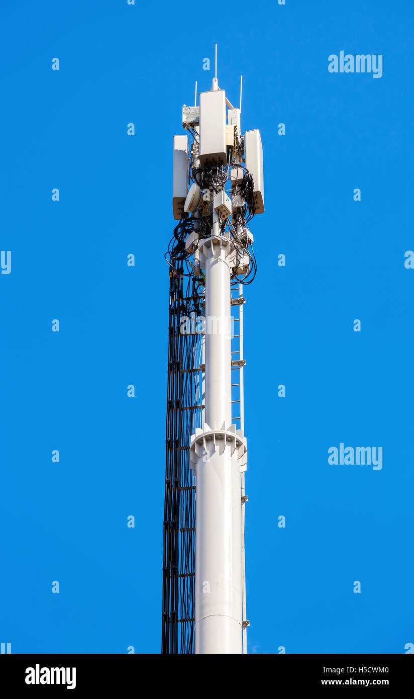Telecommunication tower for mobile phone with antennas over a blue sky ...