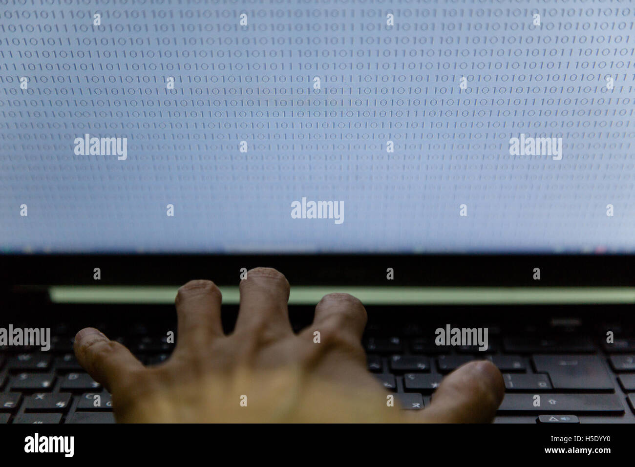 Black numbers zero and one as a texture on a blue background, laptop ...