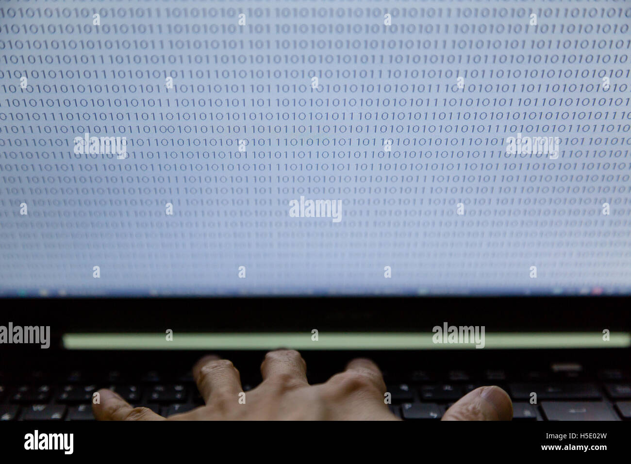 Black numbers zero and one as a texture on a blue background, laptop ...