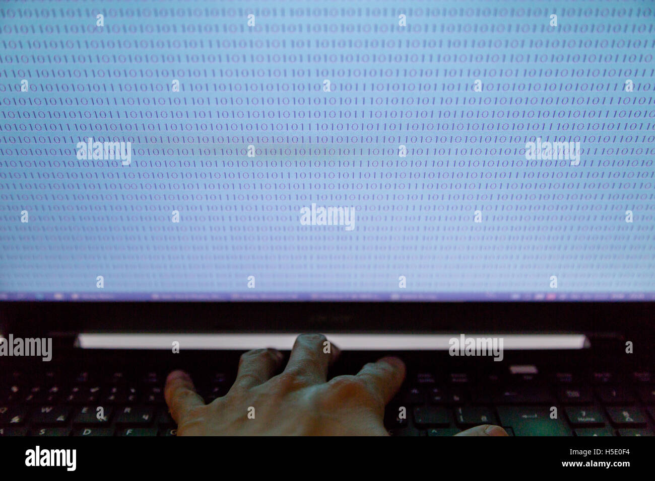 Black numbers zero and one as a texture on a blue background, laptop ...