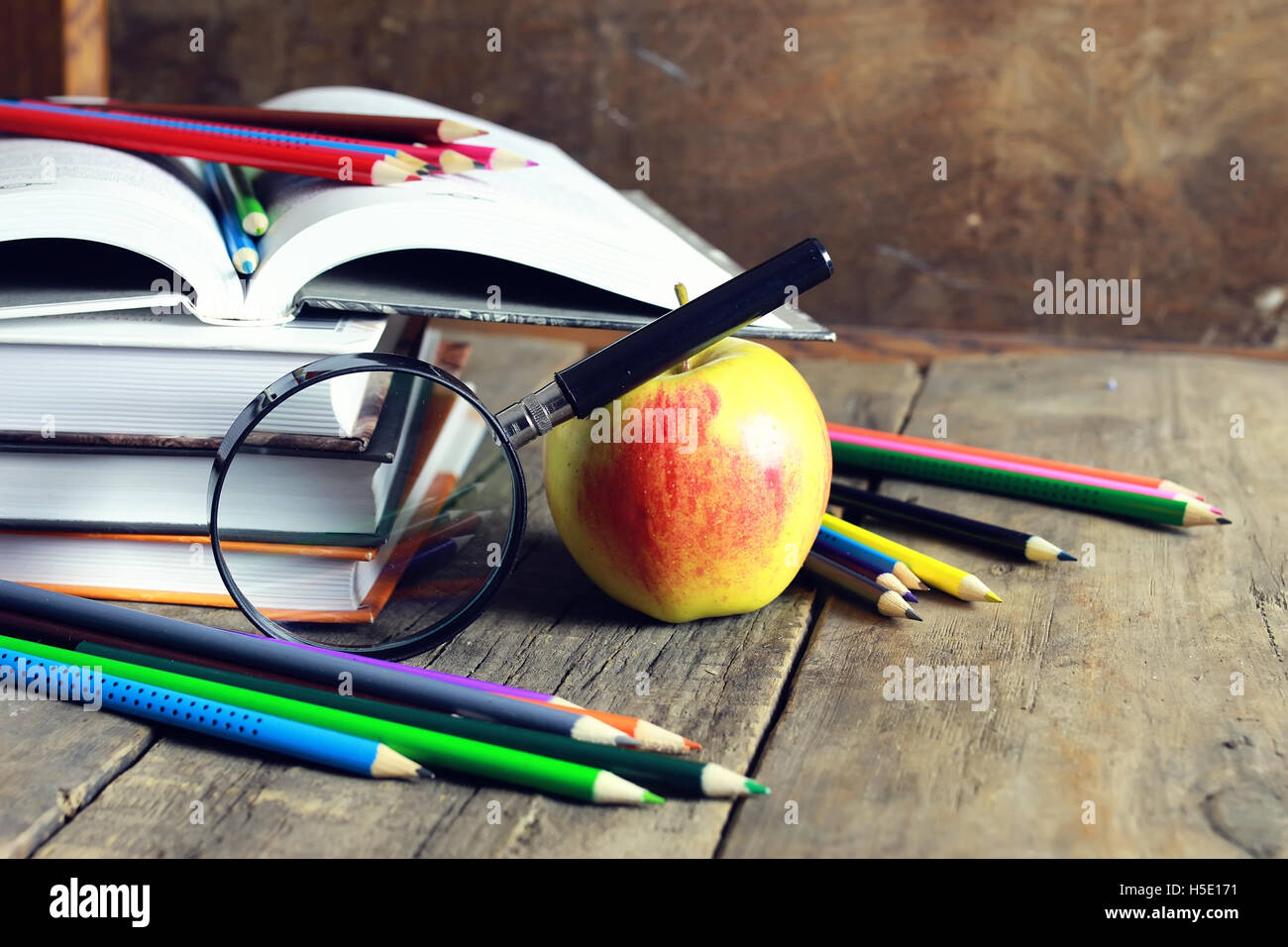 education book apple and magnifying glass Stock Photo - Alamy