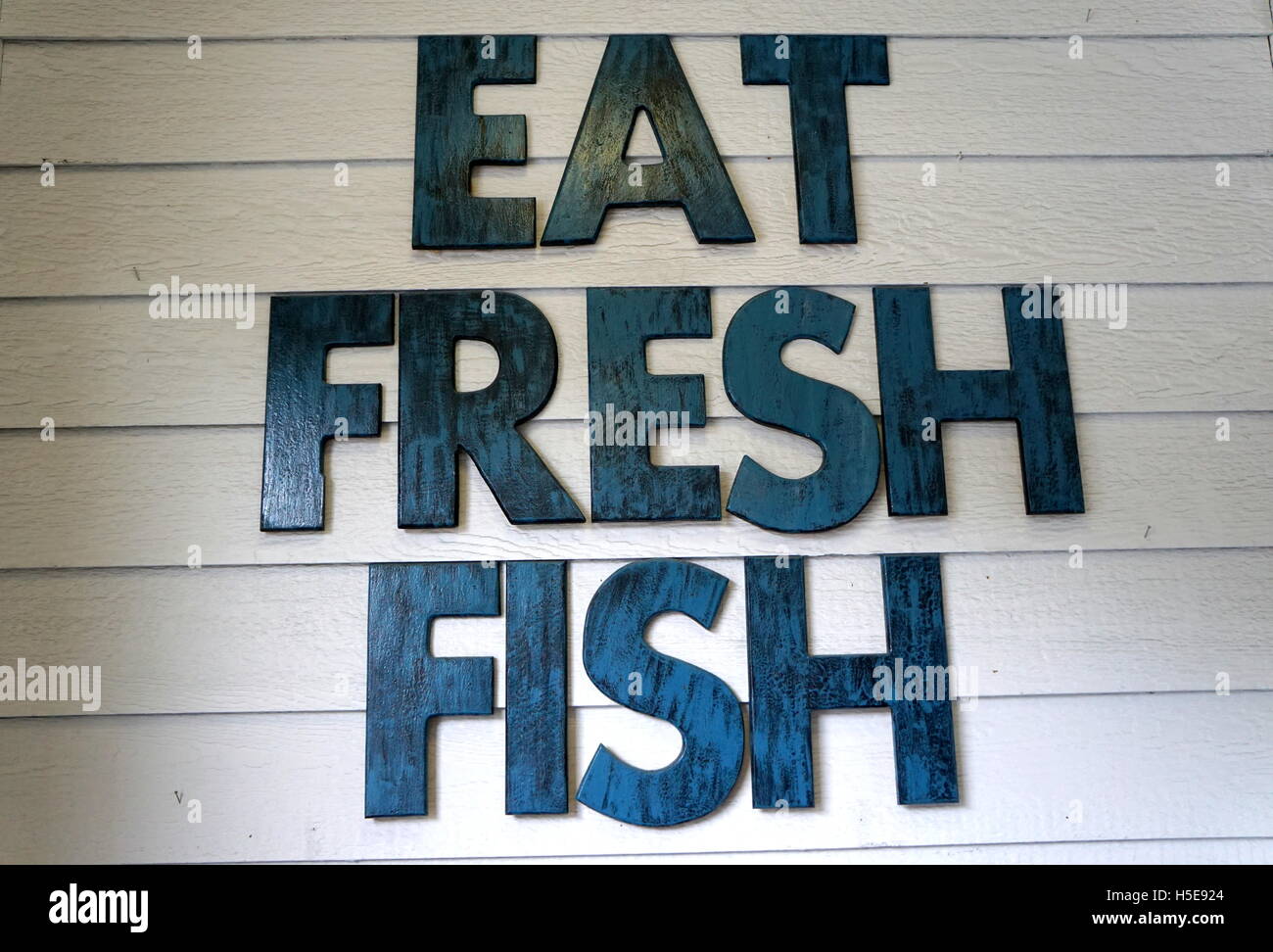 "Eat Fresh Fish" blue sign on white wall at the entrance of Chinook ...