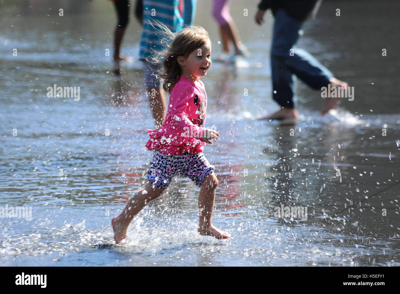 Little girl running in the water Stock Photo - Alamy