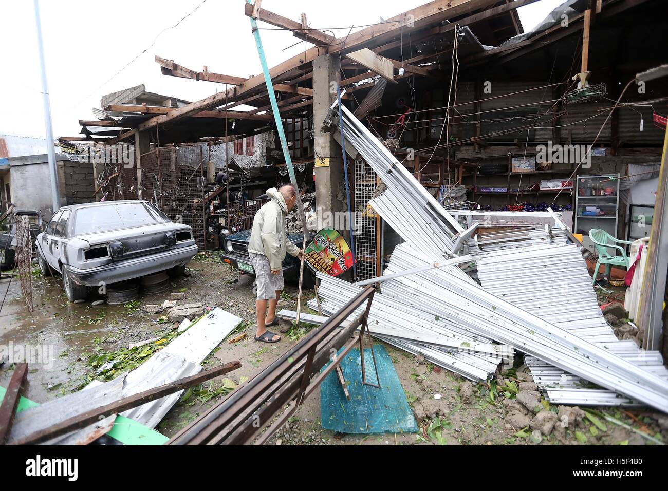 Cagayan Province. 20th Oct, 2016. A resident clears the debris brought ...