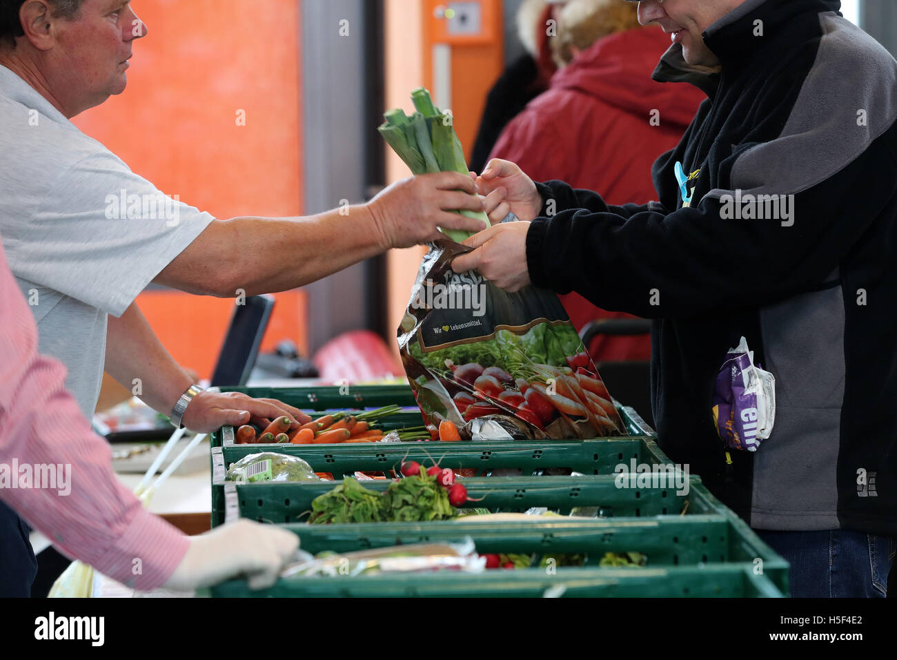 Volunteers of the Nuremberg food bank handing out food to people in ...