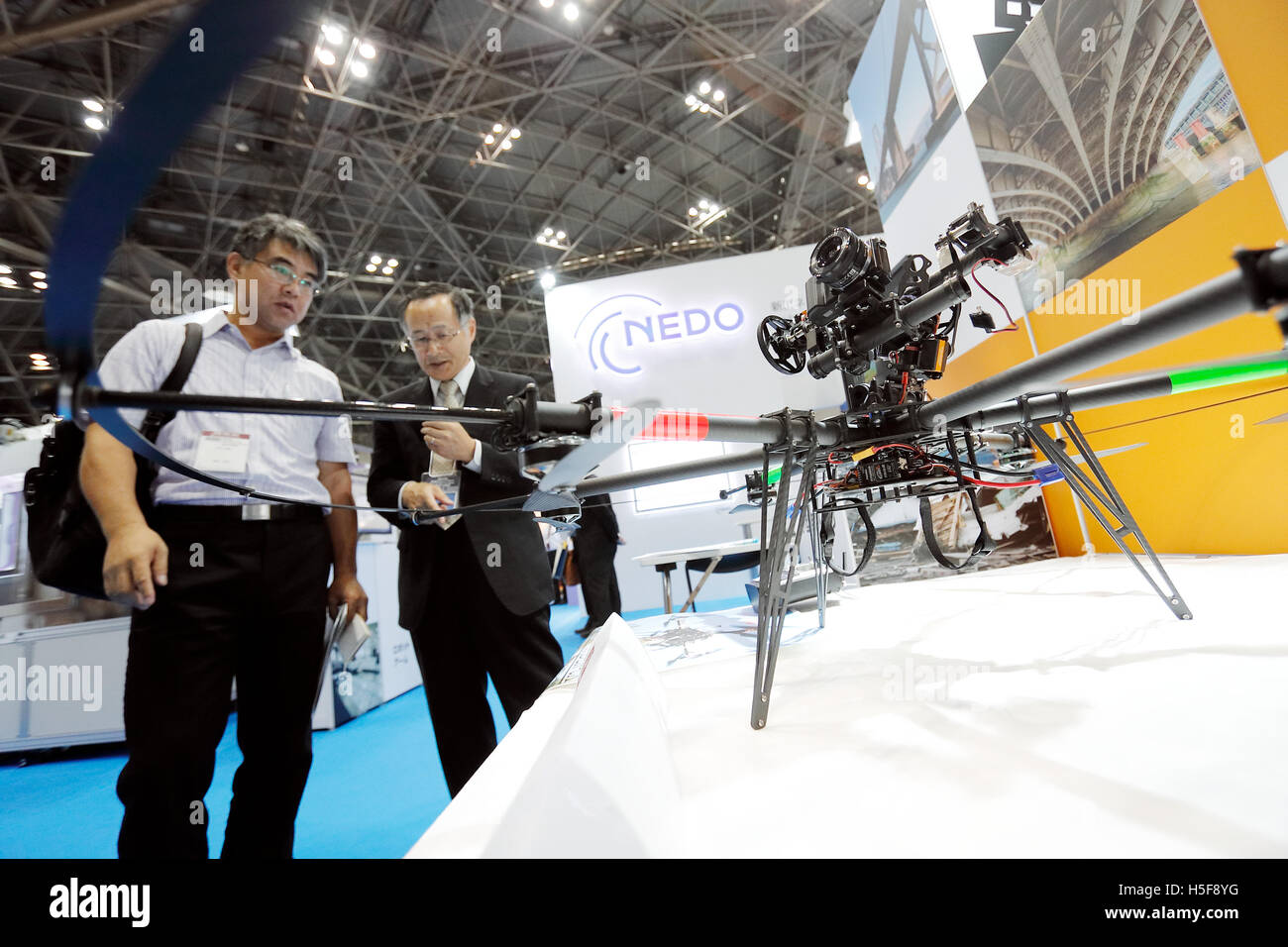 Visitors look at a drone on display during the Japan Robot Week 2016 in ...