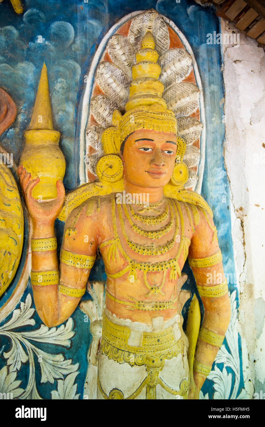 Statues at the ancient cave temple with Dambulla style paintings ...