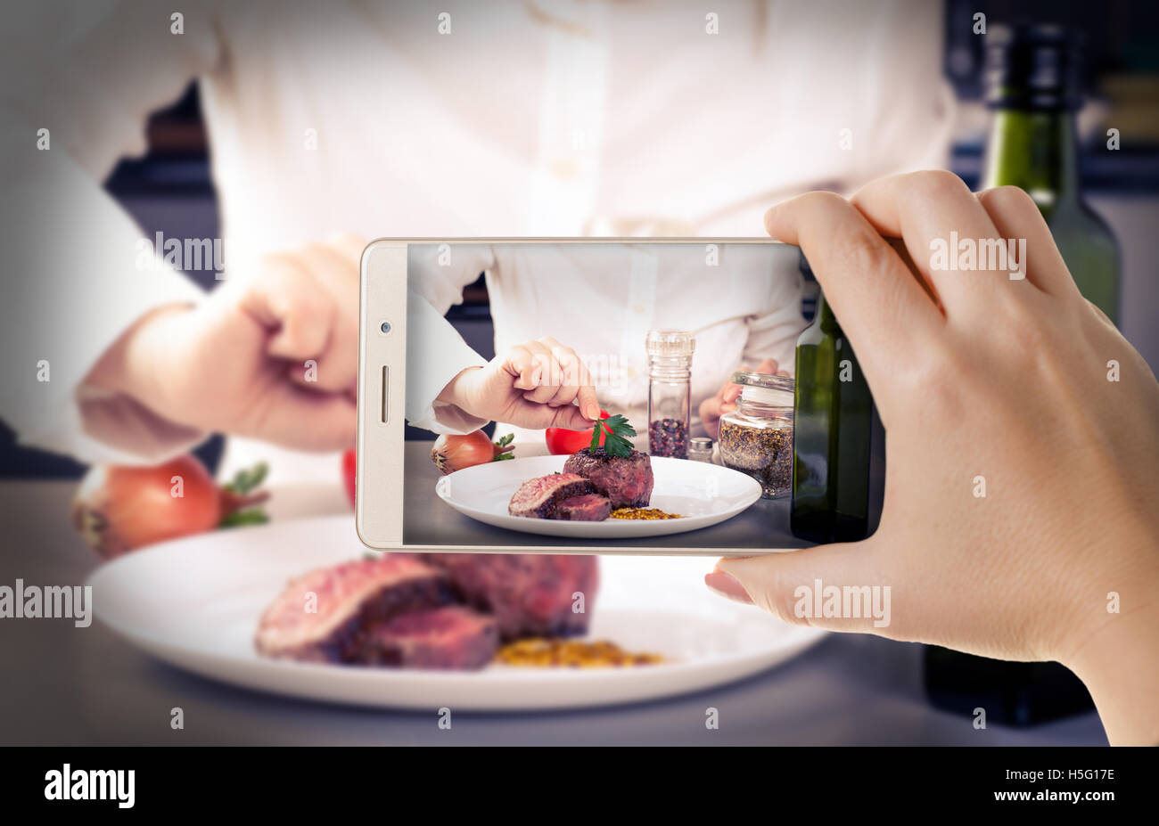 Hands with the phone close-up.Woman photographs the cooked meat to a ...