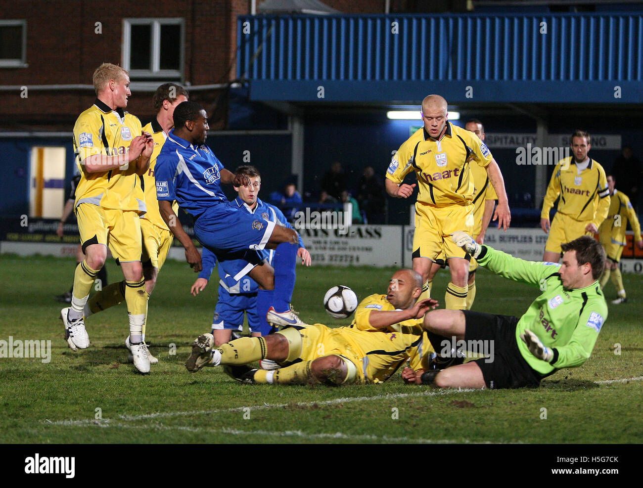 Rushden goalkeeper Dale Roberts and Simon Downer (grounded) combine to ...