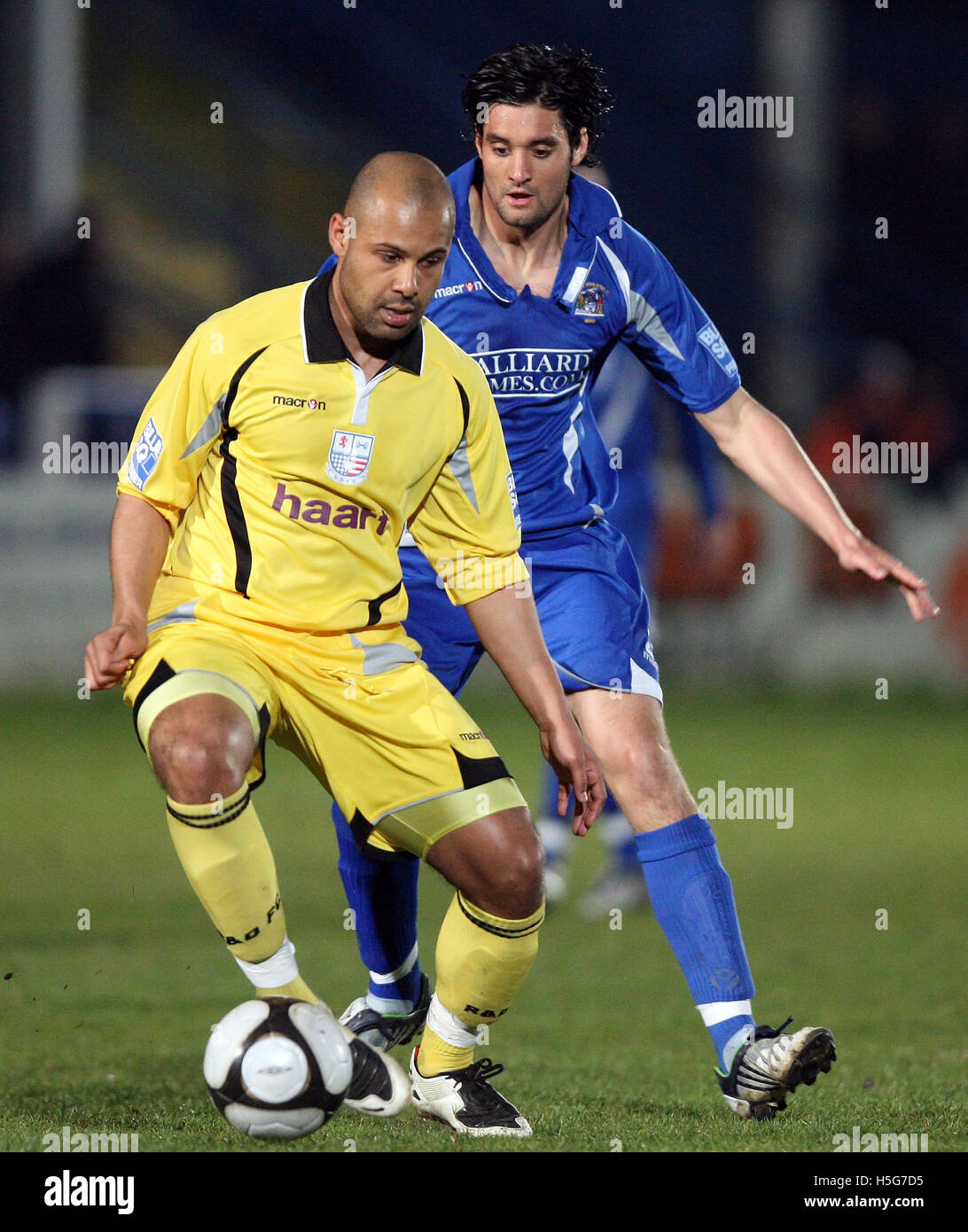 Simon Downer of Rushden shields the ball from Jamie Slabber of Grays ...