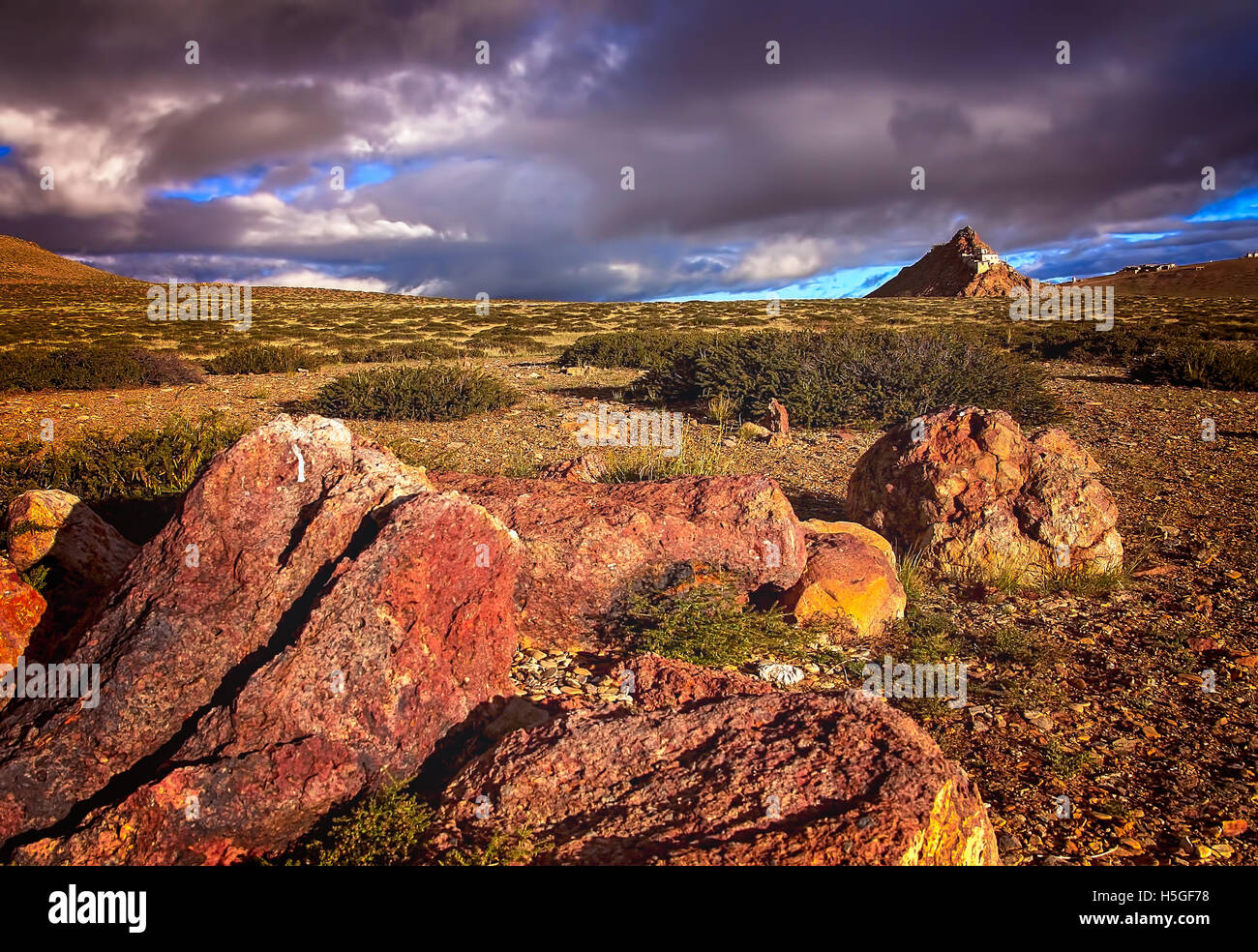 Red rocks on the tibetan plateau near to holy Lake Manasarovar with a ...