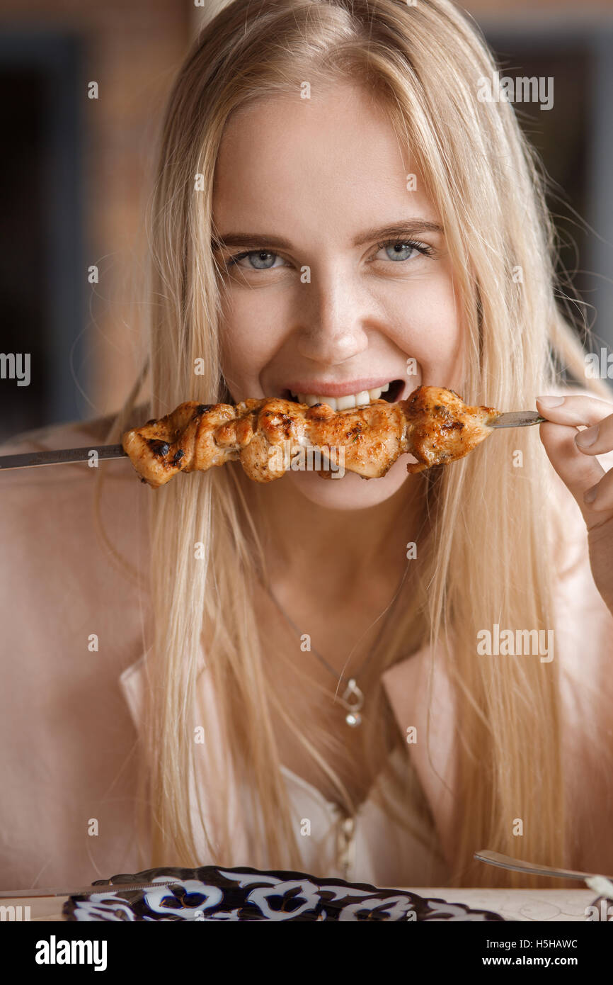 beautiful happy woman in cafe eating fired meat Stock Photo - Alamy