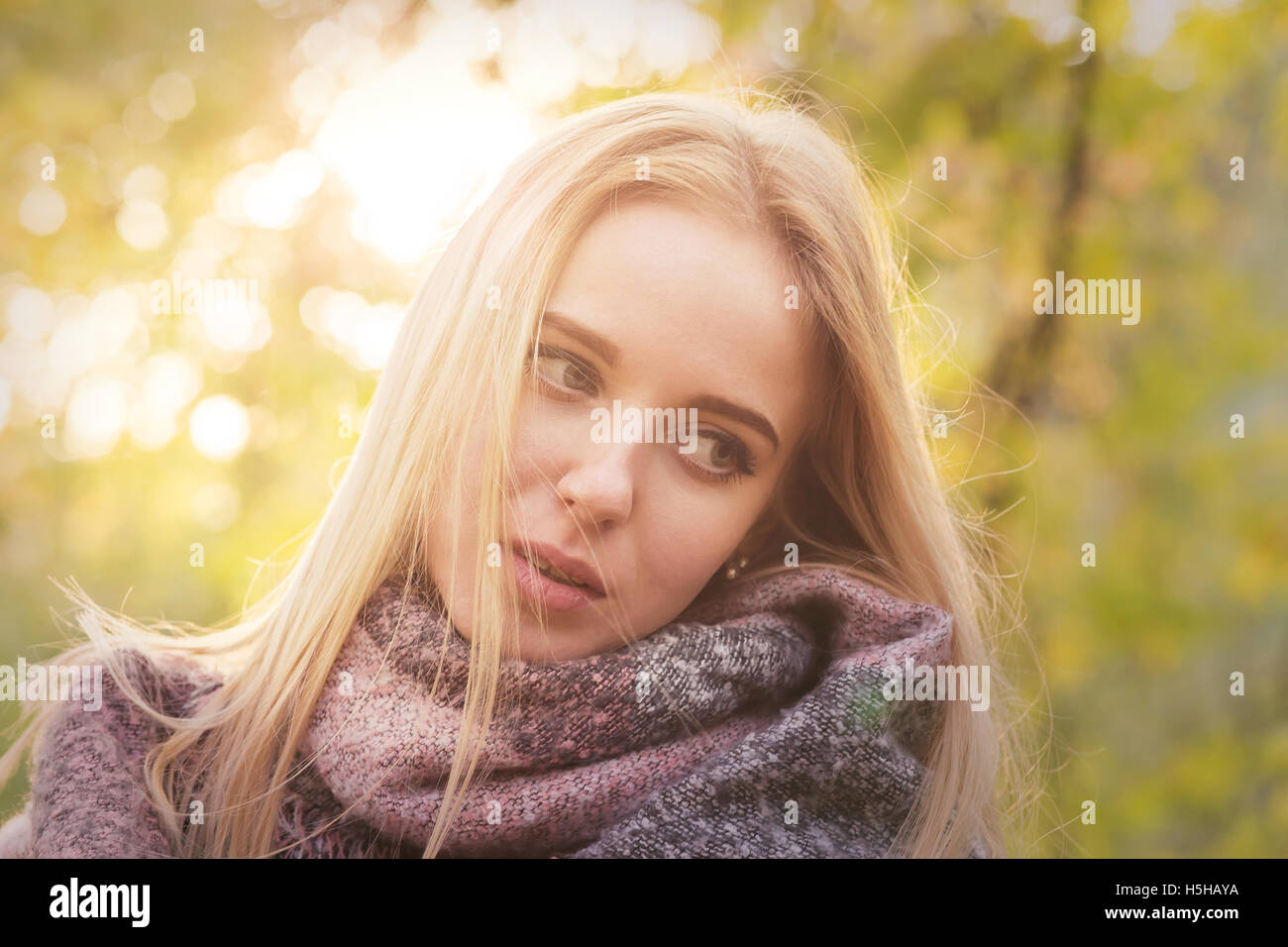 sad girl in scarf in sunlight in autumn park Stock Photo - Alamy