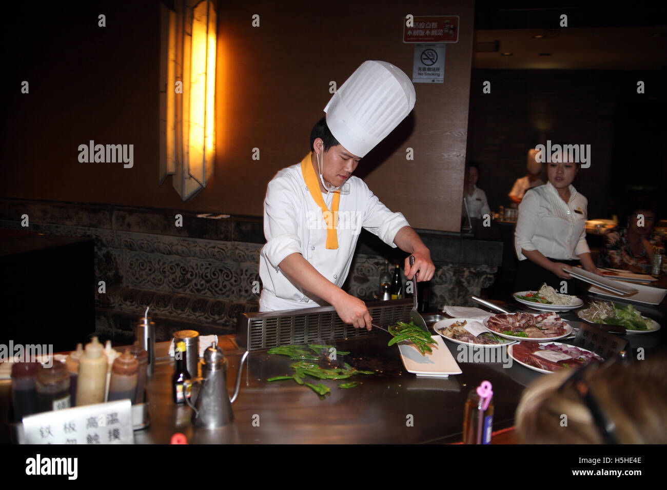 Chinese cook in a Chinese restaurant wearing white uniform and a cap ...