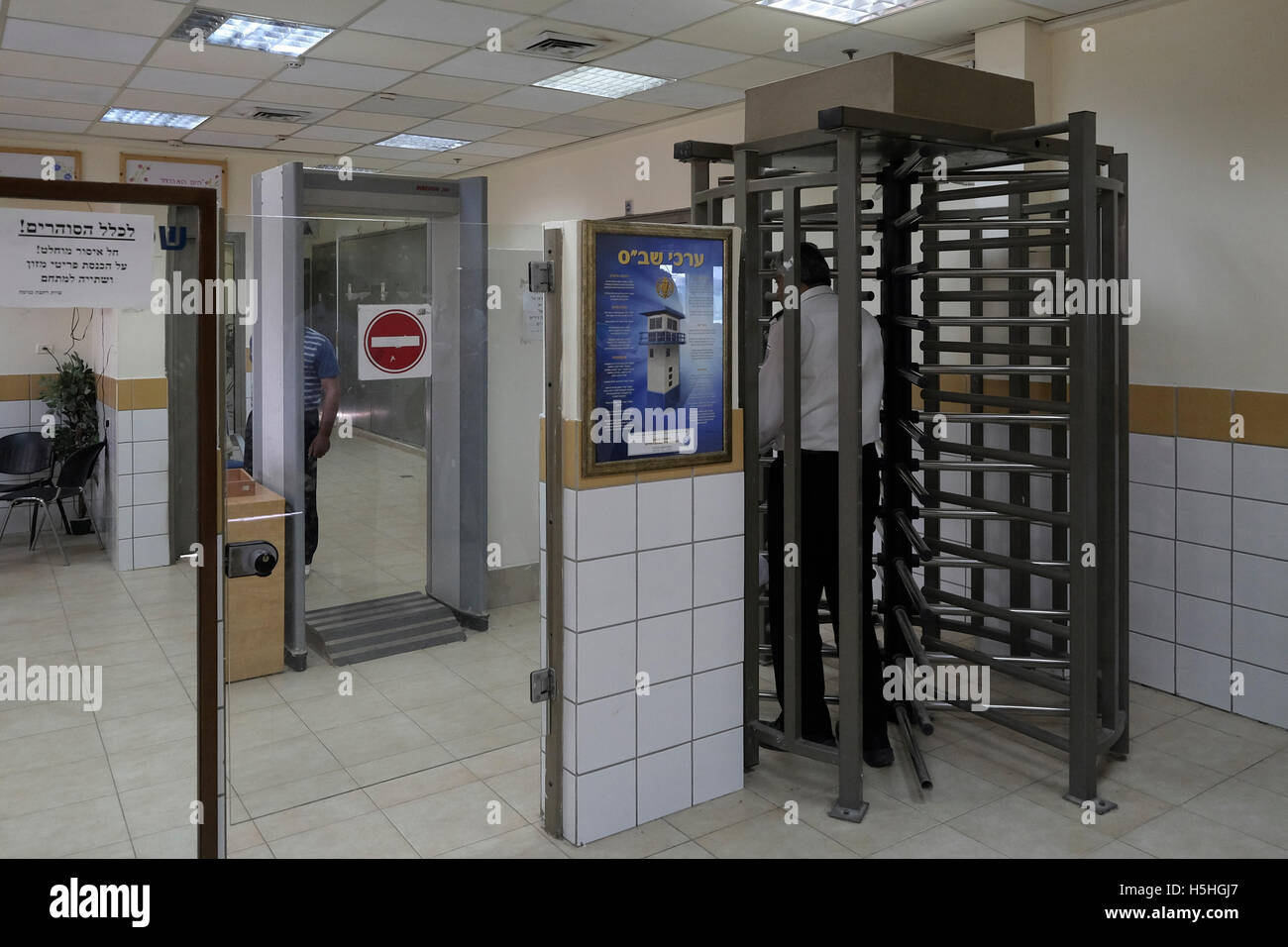 A visitor moves through stainless steel security turnstile at the ...