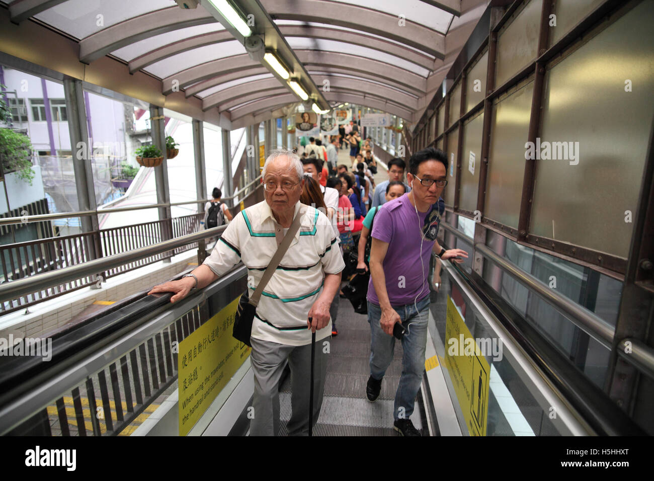 People on an escalator, some stand like this old man, others rush by ...