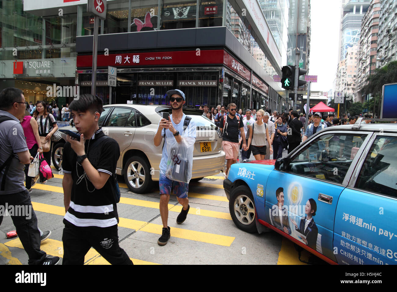 Lots of people crossing the street on a crossroad walking between cars ...