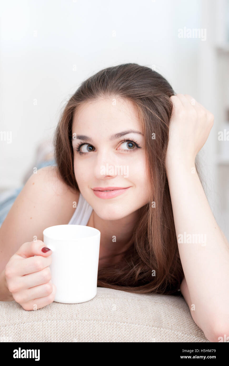 Happy girl on the couch at home in the living room Stock Photo - Alamy