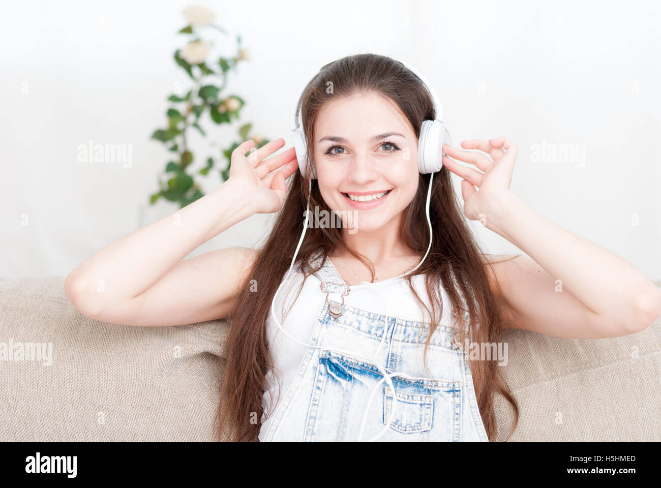 Happy girl on the couch at home in the living room Stock Photo - Alamy