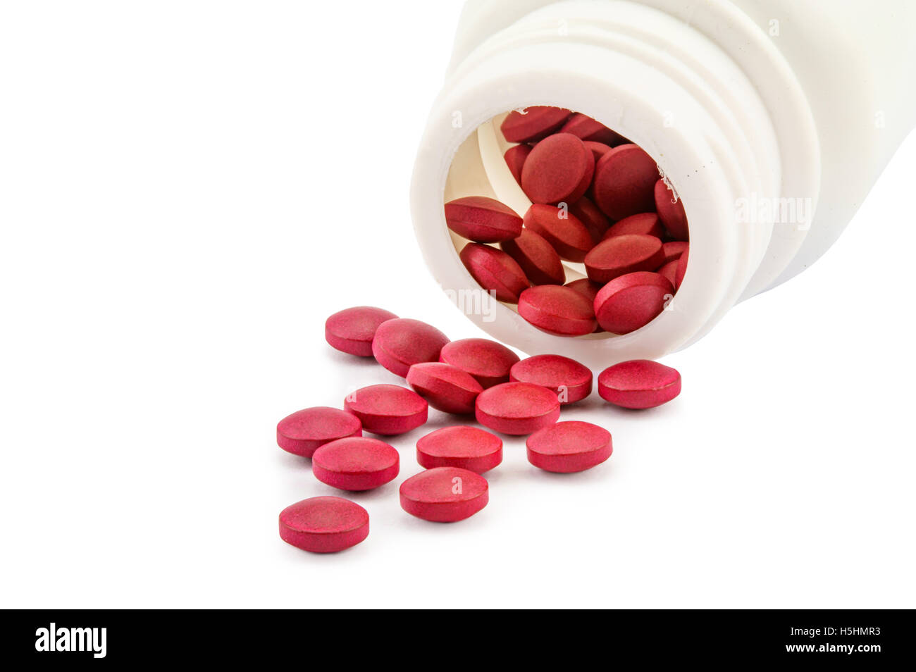Red pills and white plastic bottle on white background Stock Photo - Alamy