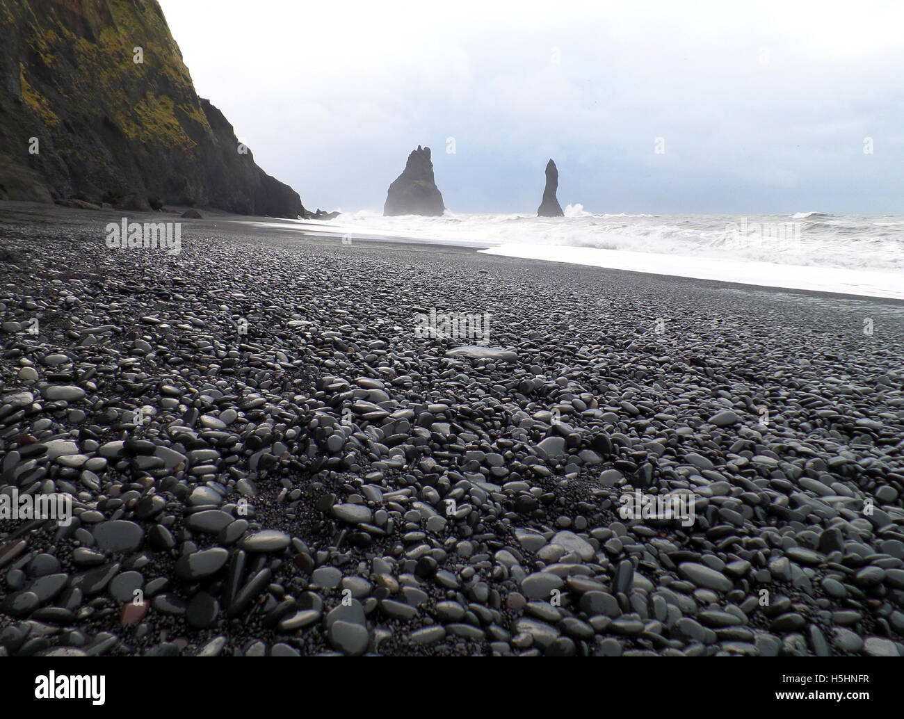 Reynisdrangur sea stacks and black sand beach in a windy day, Vik of ...