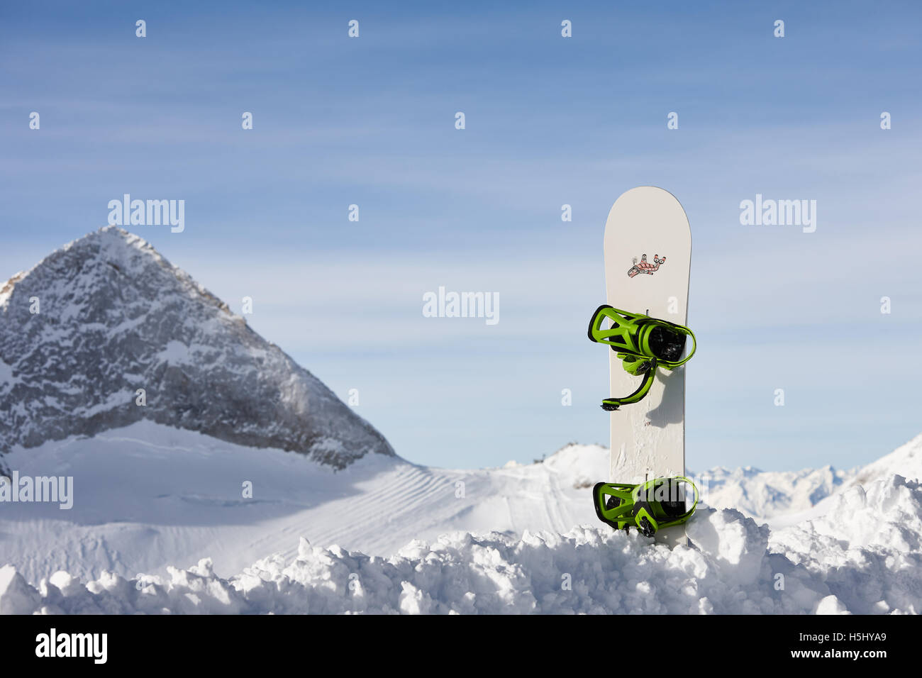 Snowboard in snow slope on a beautiful mountain background Stock Photo ...