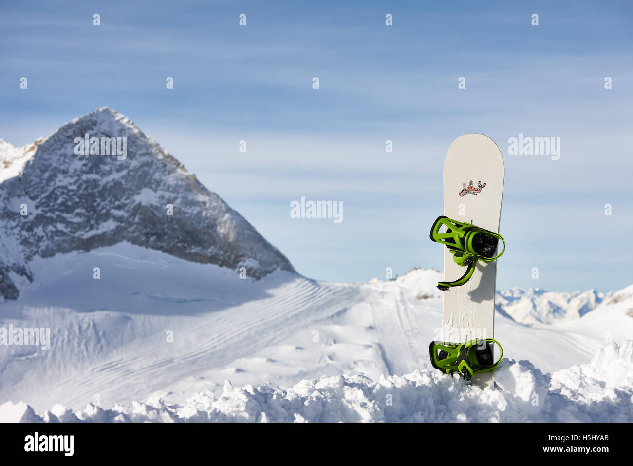 Snowboard in snow slope on a beautiful mountain background Stock Photo ...