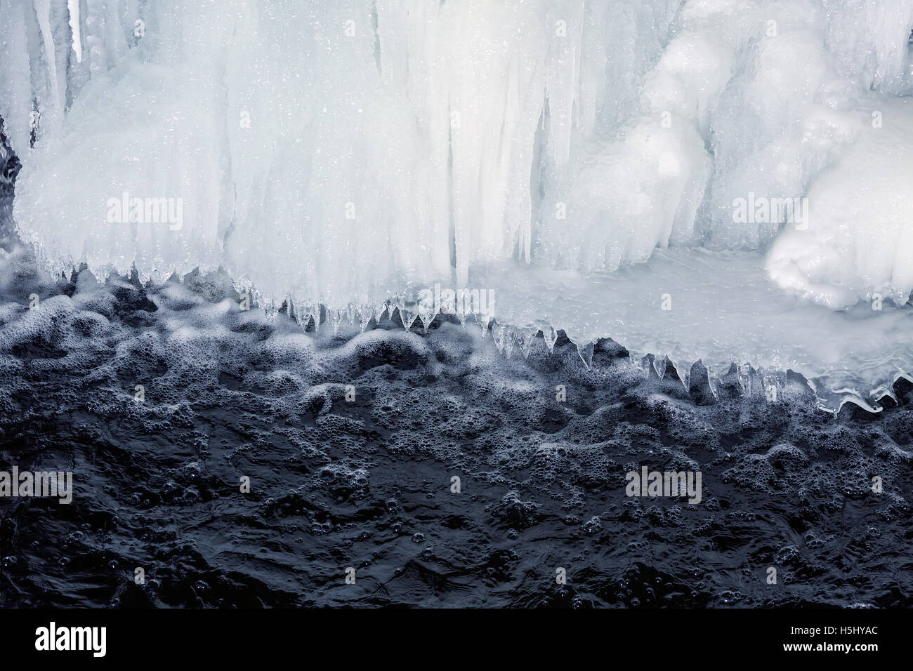 Winter stream with cluster of icicles over running water Stock Photo ...