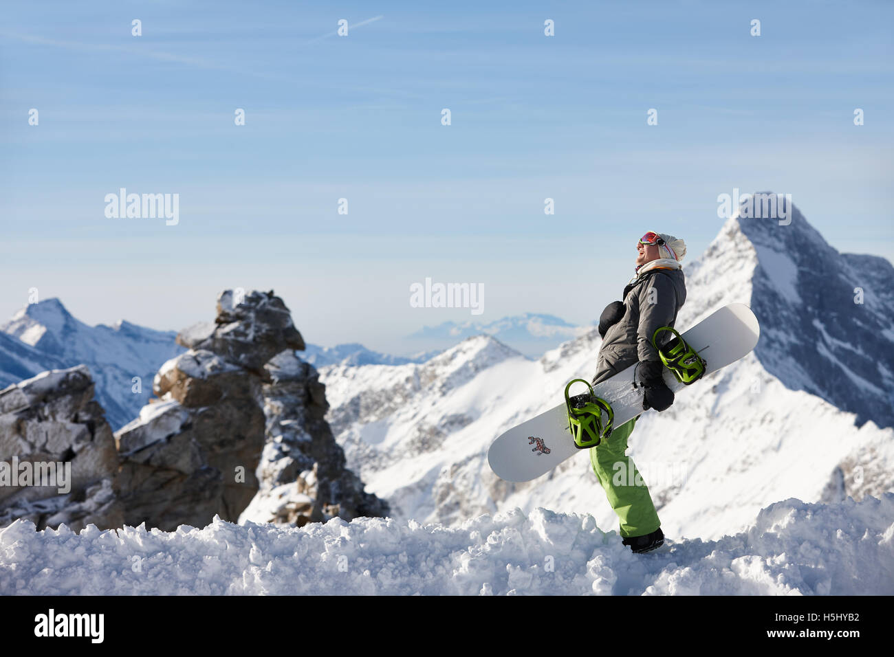 Snowboarder watching mountain landscape Stock Photo - Alamy
