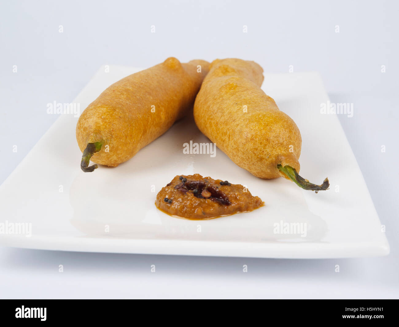 chilli baji with onion chutney on white background Stock Photo - Alamy