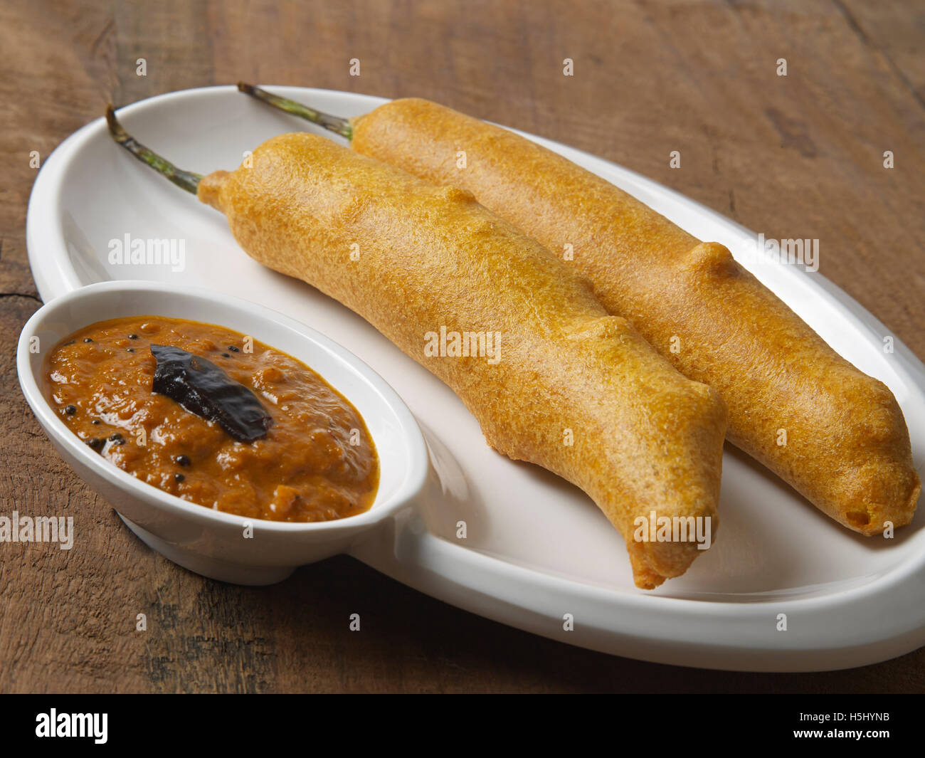 chilli bajji with onion chutney a south Indian snack in a dip plate on ...