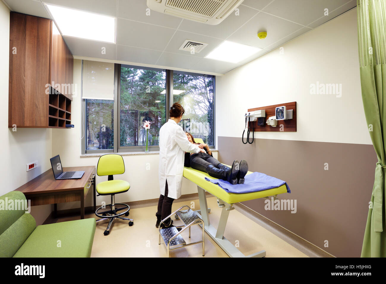 A general practitioner doctor exams a patient in a clean new modern ...