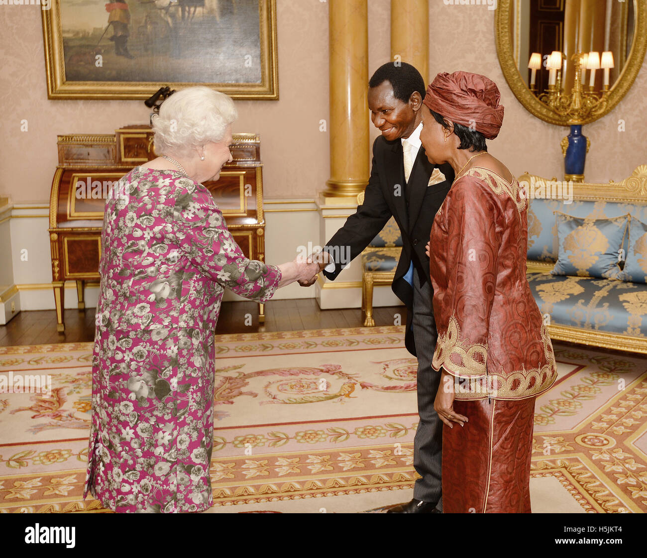 Queen Eliabeth II shakes hands with Mr Cleophas Migiro the husband of ...