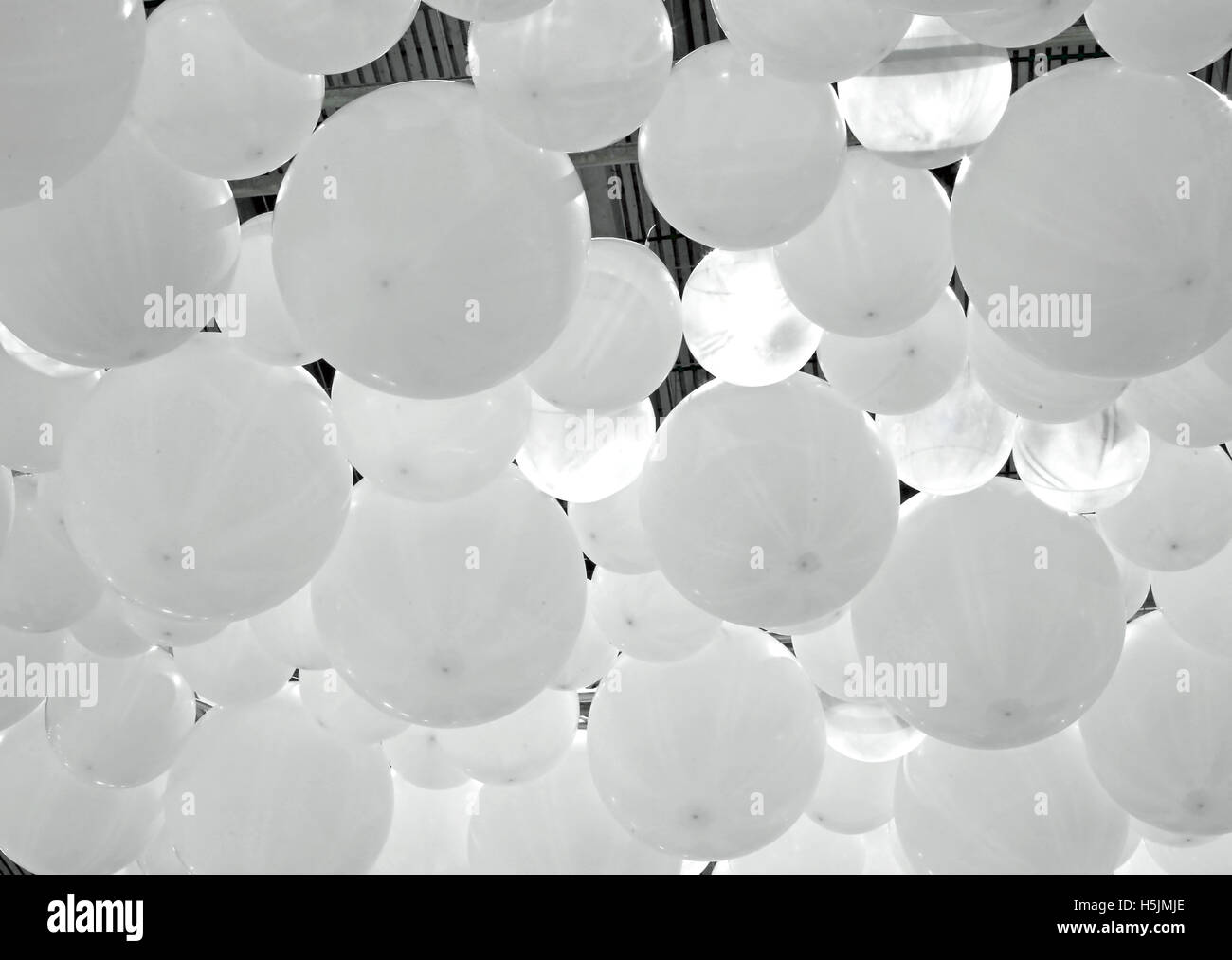 many big white balloons hanging from the ceiling during a ceremony and ...