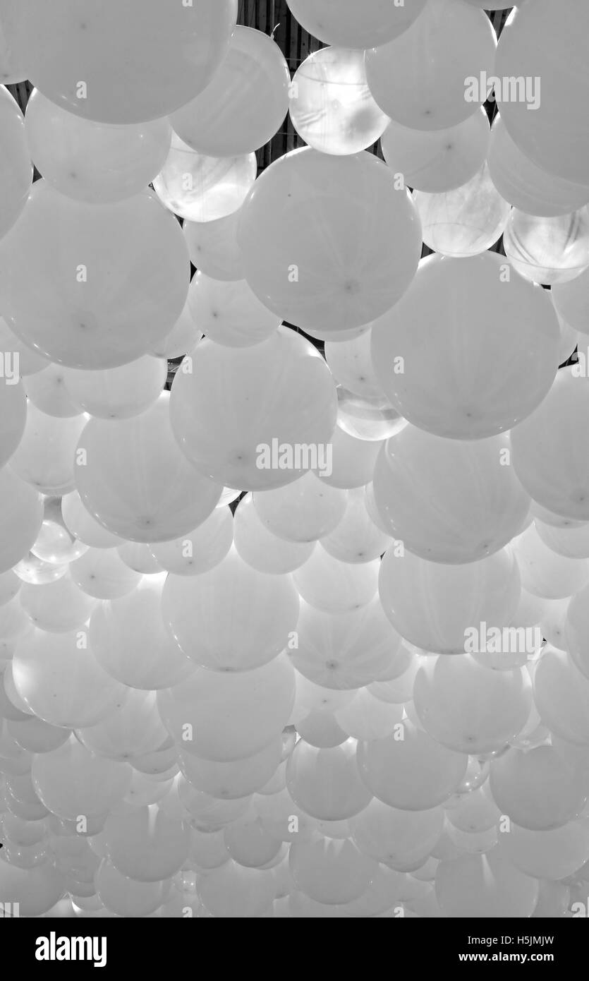 many big white balloons hanging from the ceiling during a ceremony and ...